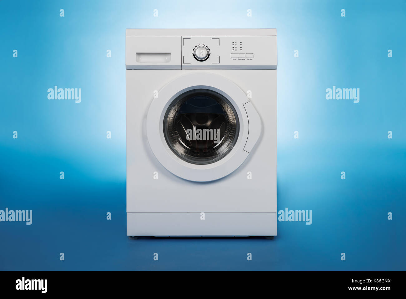White washing machine isolated over blue background Stock Photo - Alamy