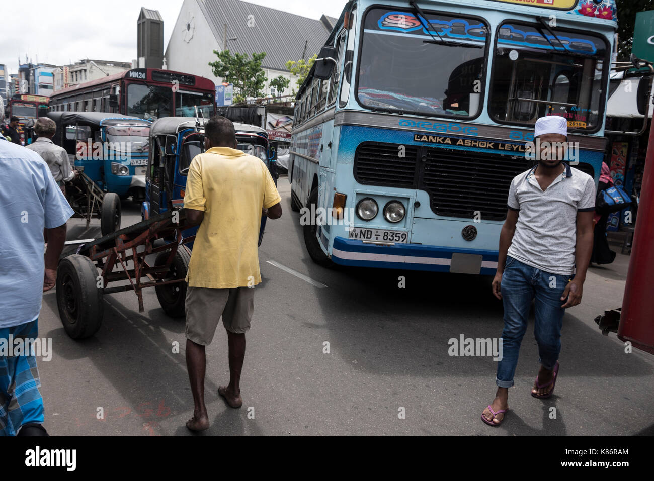 Both local traffic and pedestrians weaving in between in a busy street ...