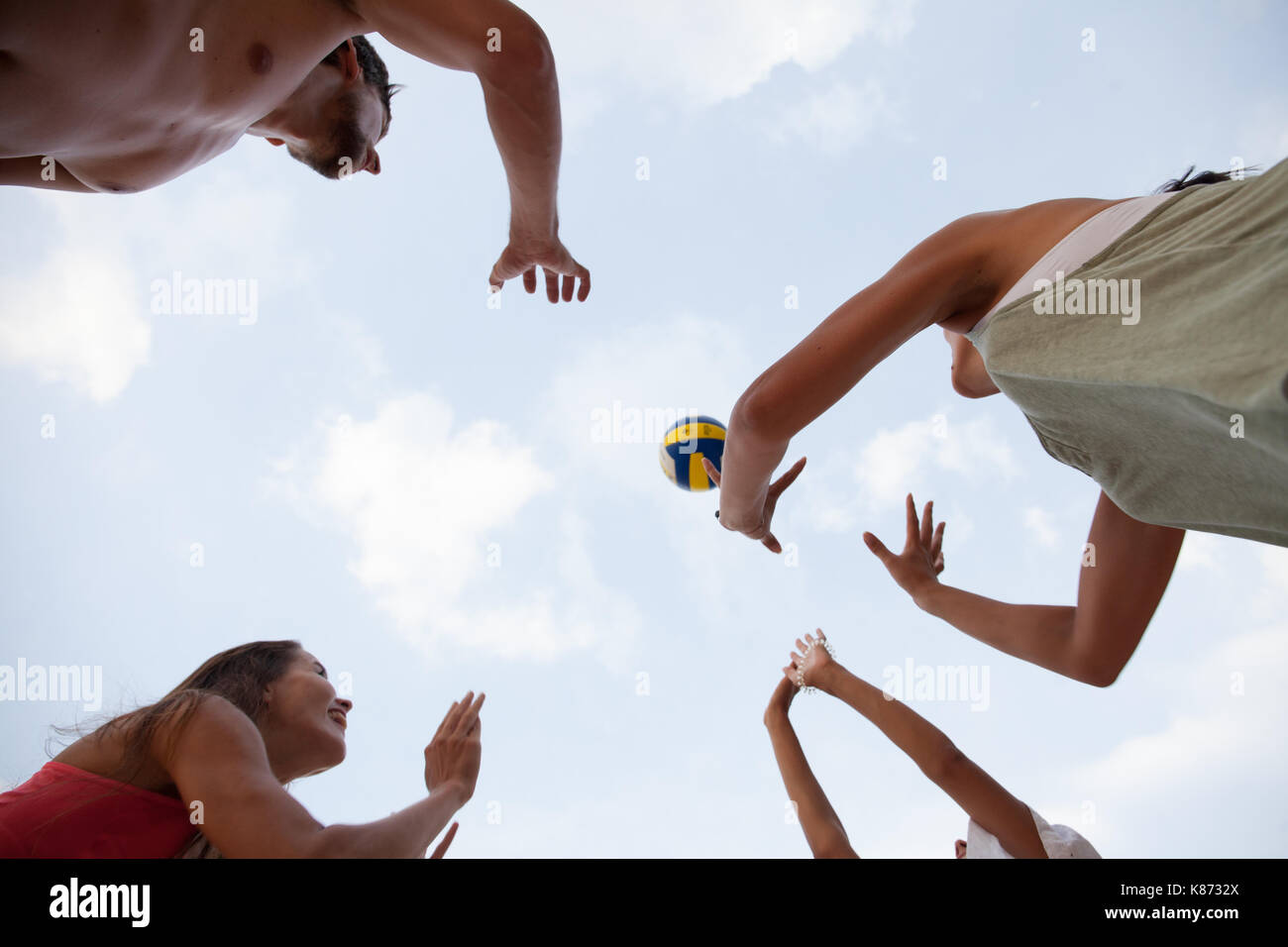 Group of young people playing volleyball outdoors Stock Photo - Alamy