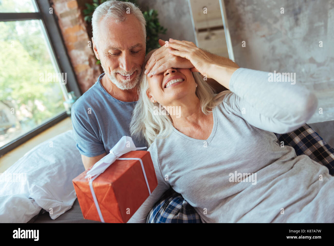 Loving aged man giving present to his nice wife Stock Photo - Alamy