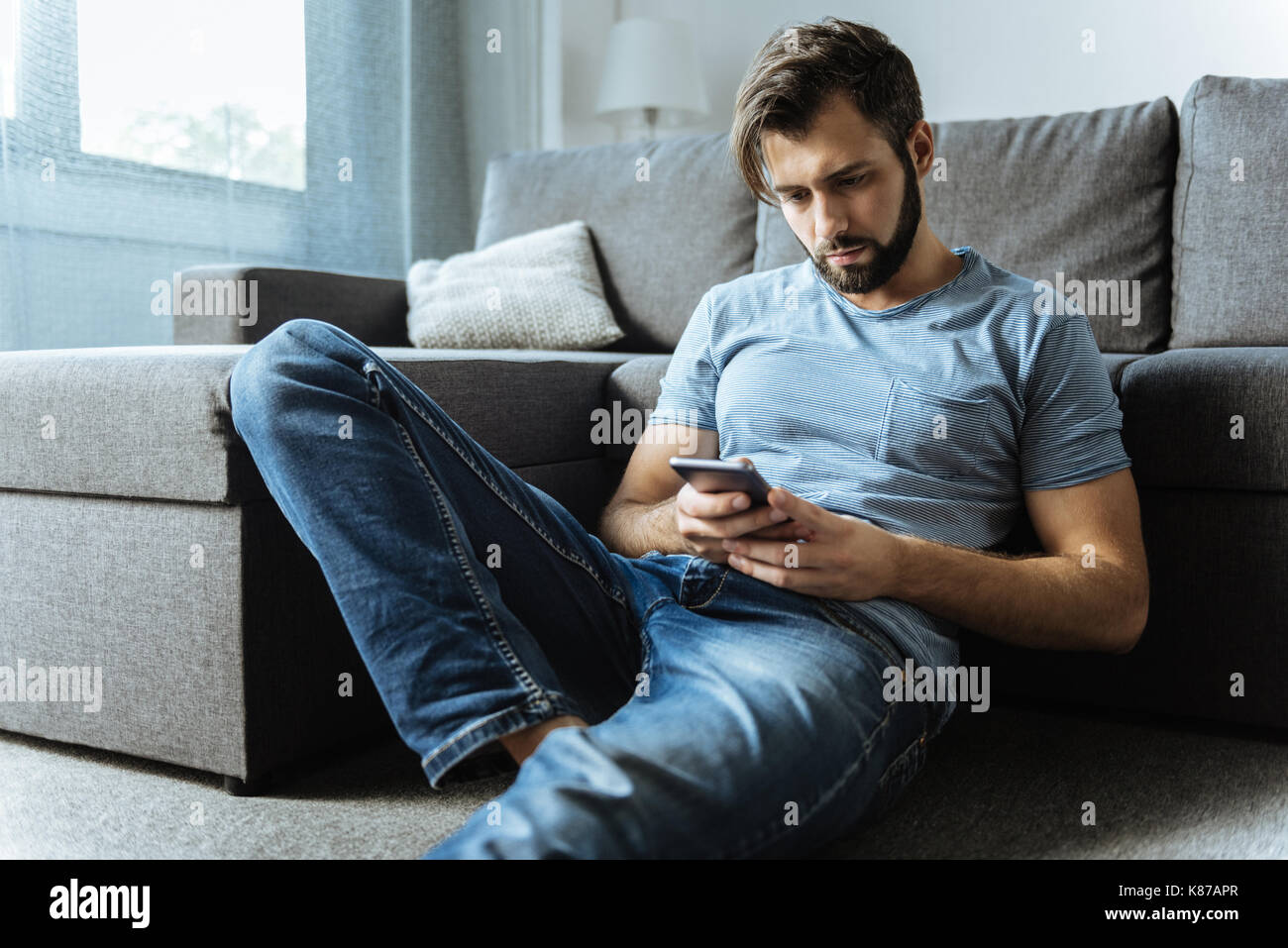 Sad handsome man checking his messages Stock Photo - Alamy