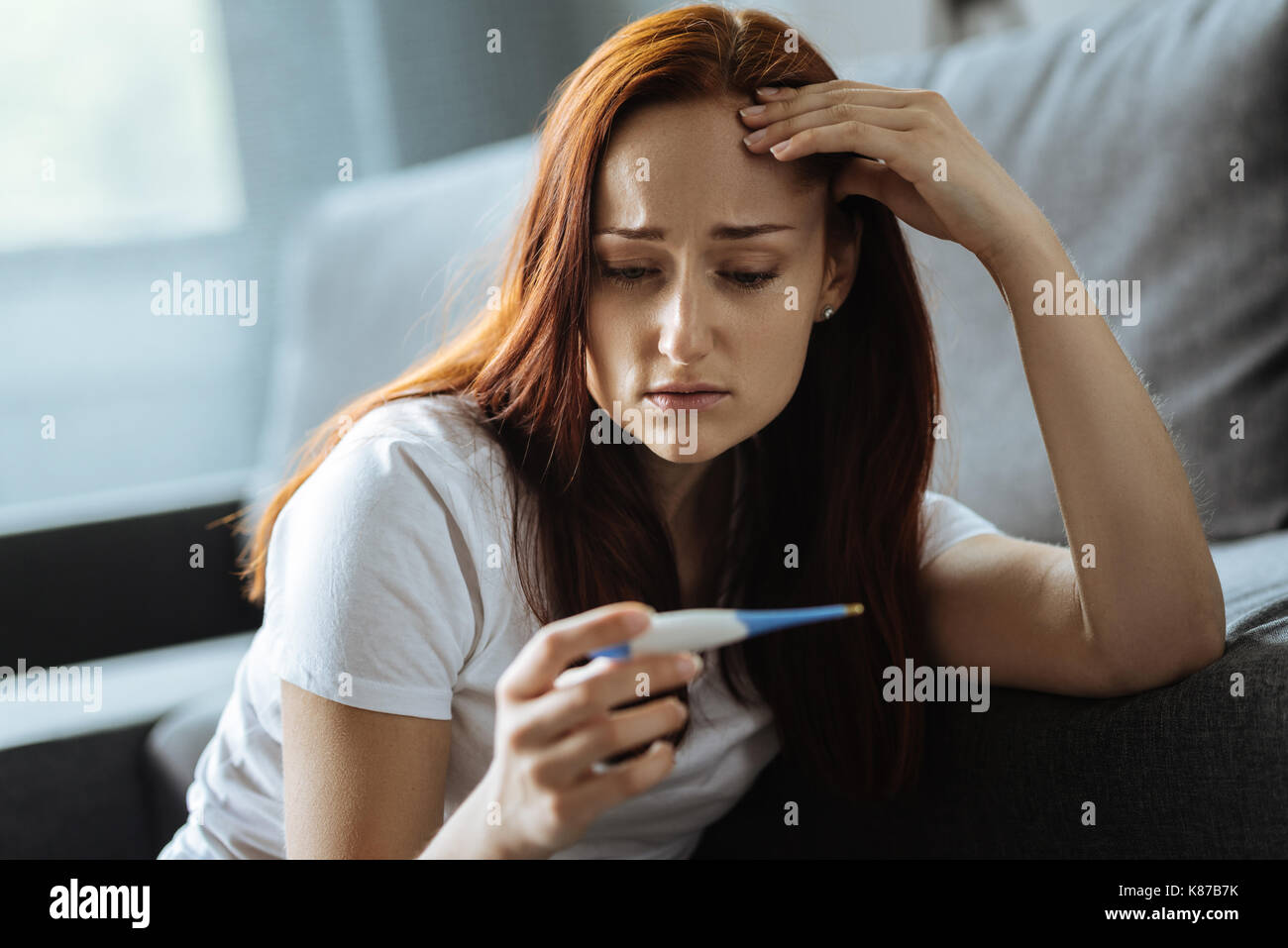 Sad moody woman holding her forehead Stock Photo - Alamy