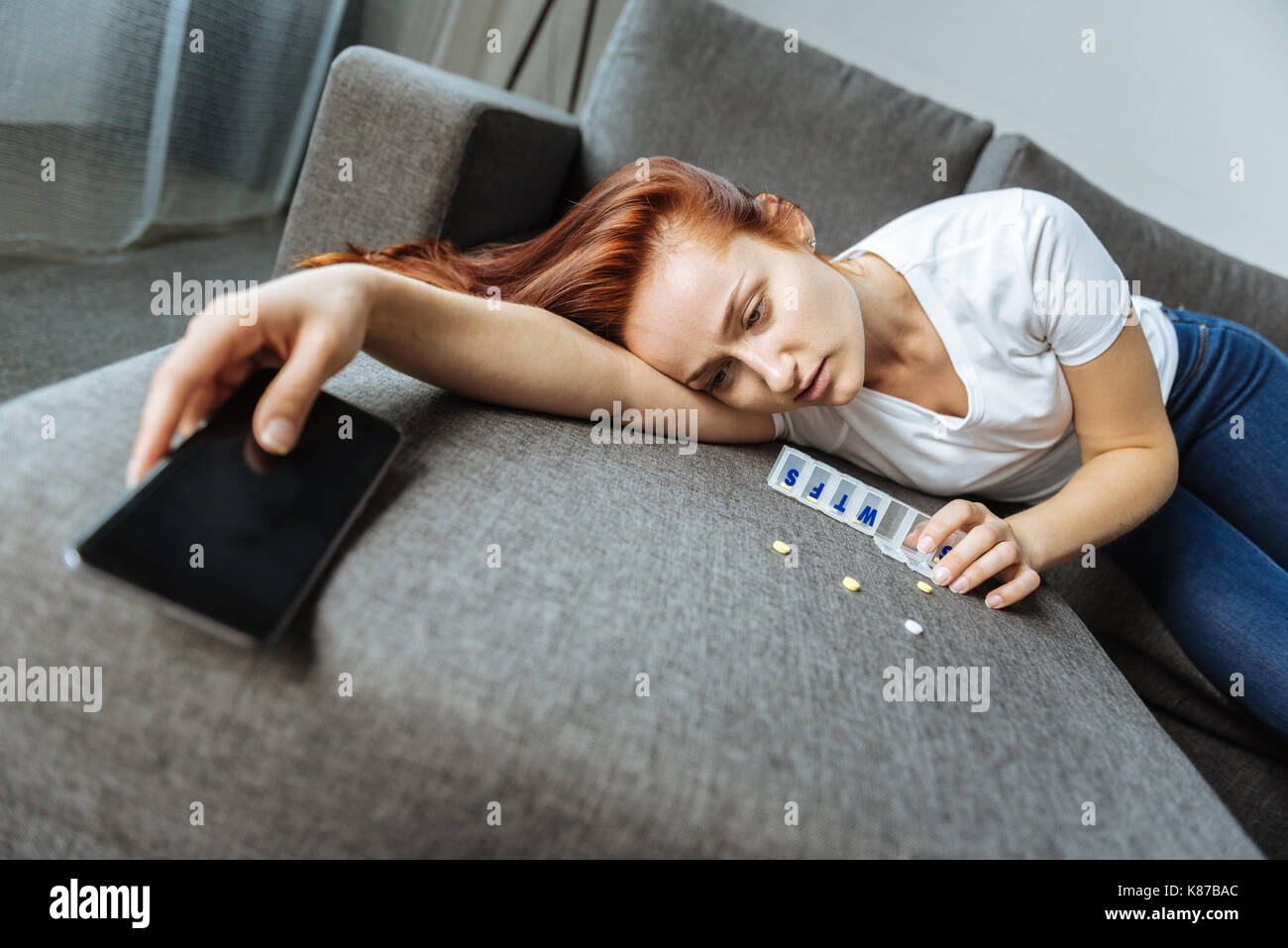 Tired gloomy woman lying on the sofa Stock Photo - Alamy