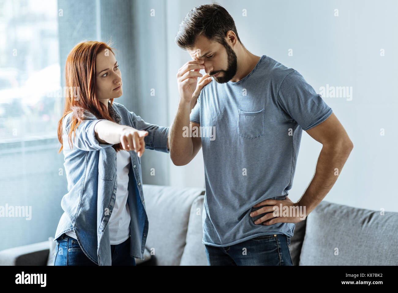 Sad cheerless woman pointing at the door Stock Photo - Alamy