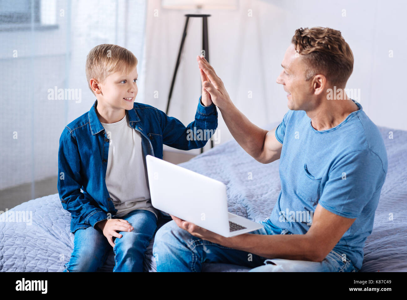 Happy boy giving his father a high-five Stock Photo - Alamy