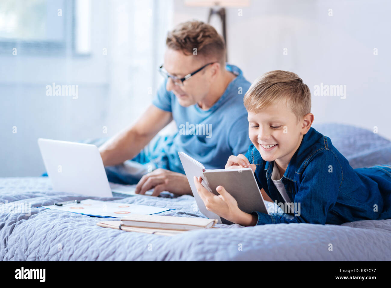 Pre-teen boy doing math homework while his father working Stock Photo ...