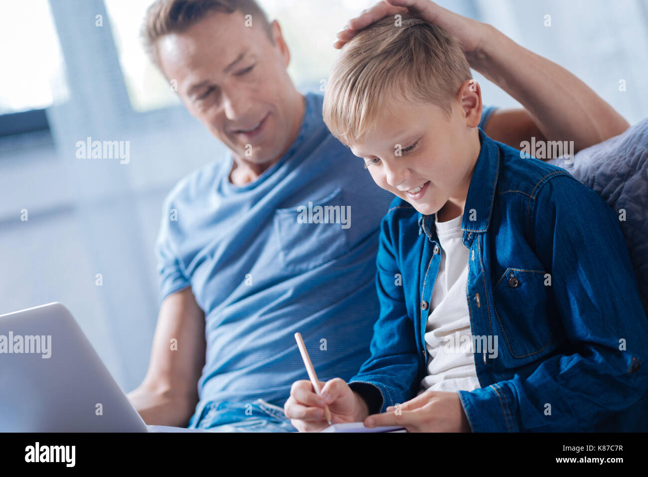 Proud father patting son on the head while he studying Stock Photo - Alamy