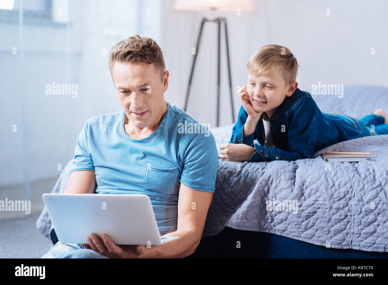 Little son watching his father work on laptop Stock Photo - Alamy