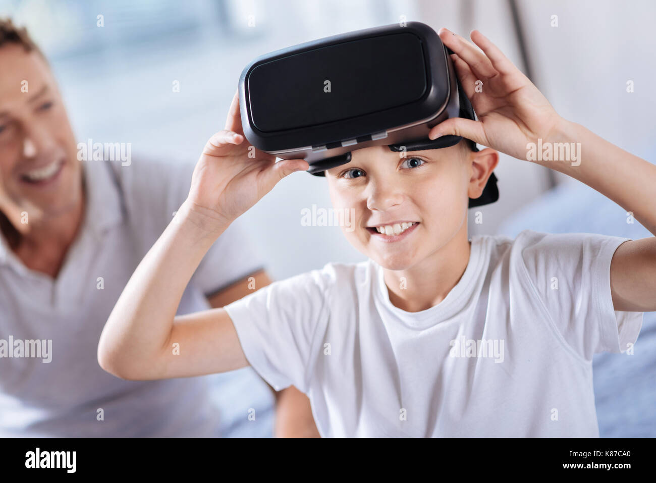 Happy excited boy removing VR headset after playing Stock Photo - Alamy