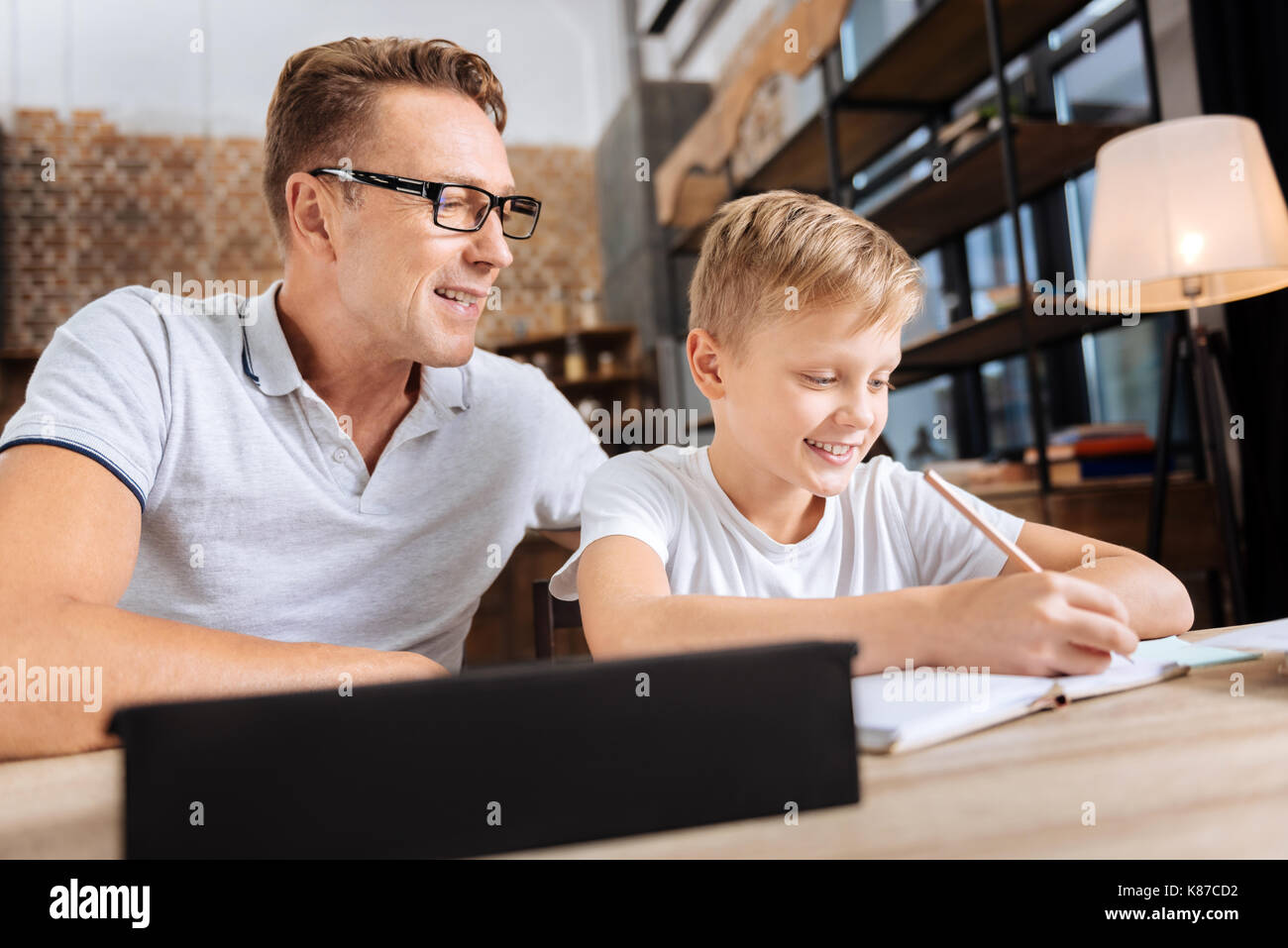 Upbeat boy doing math home assignment with father Stock Photo - Alamy