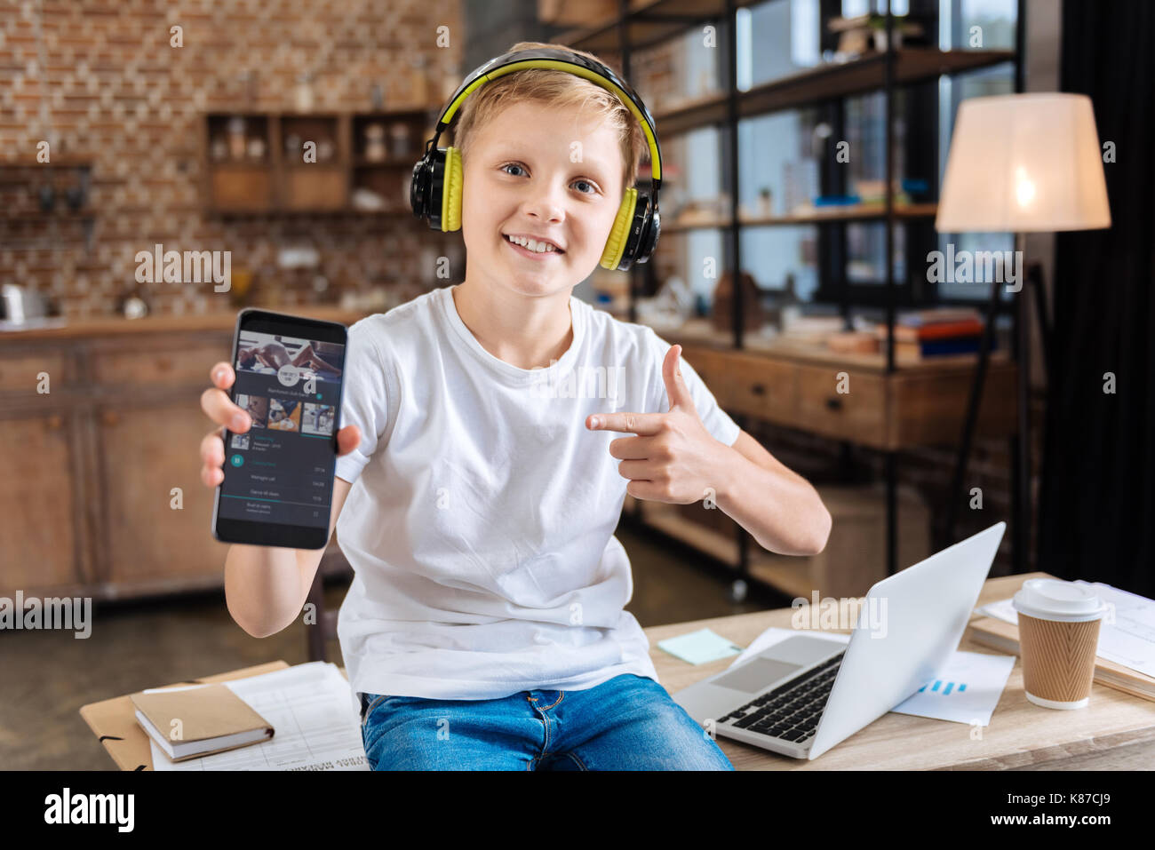 Smiling boy showing his favorite music streaming app Stock Photo - Alamy