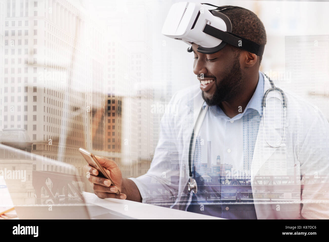 Smiling doctor holding mobile phone Stock Photo - Alamy