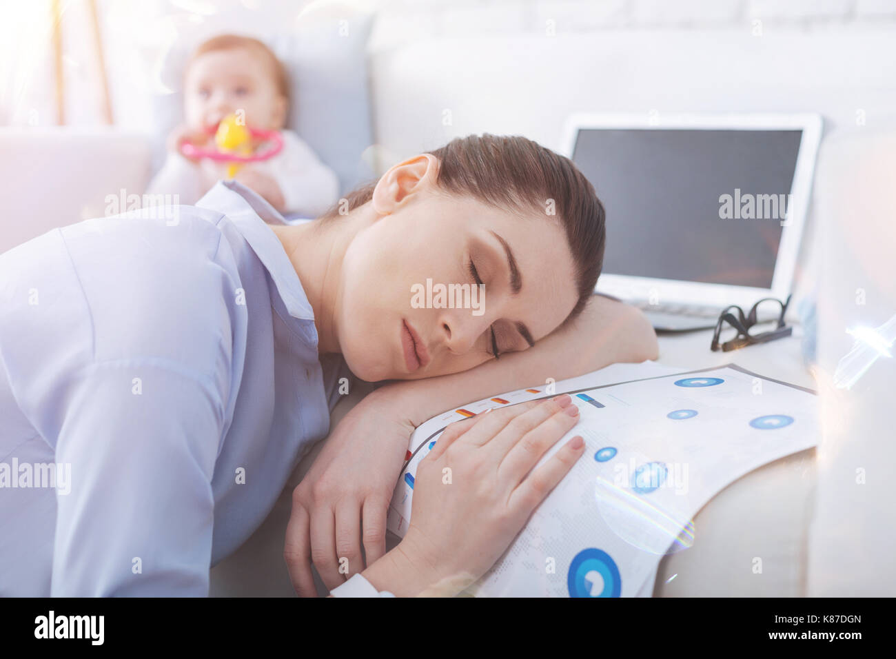 Portrait of sleepy mom putting head on her arm Stock Photo - Alamy
