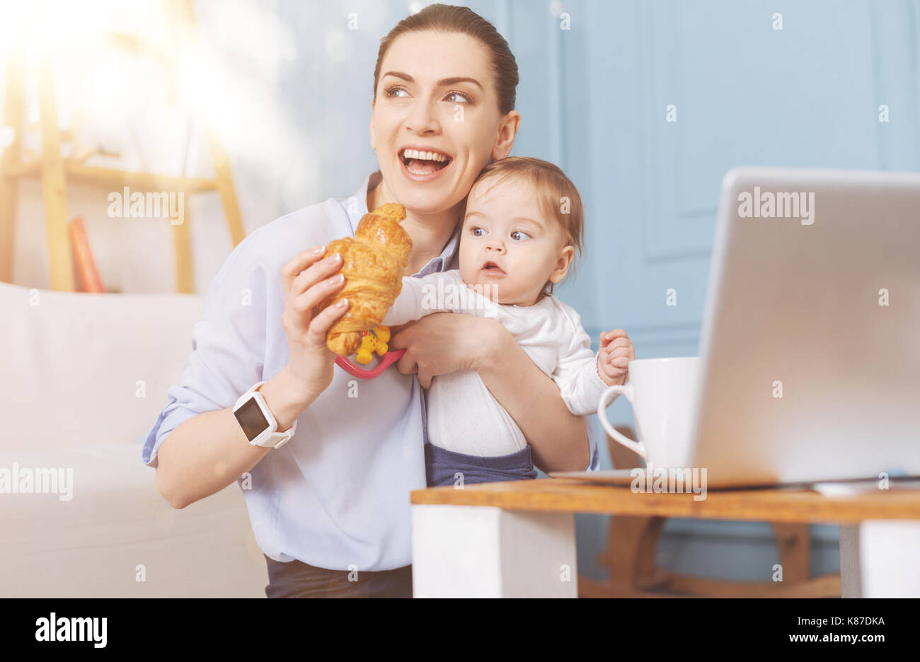 Funny baby girl looking at croissant Stock Photo - Alamy