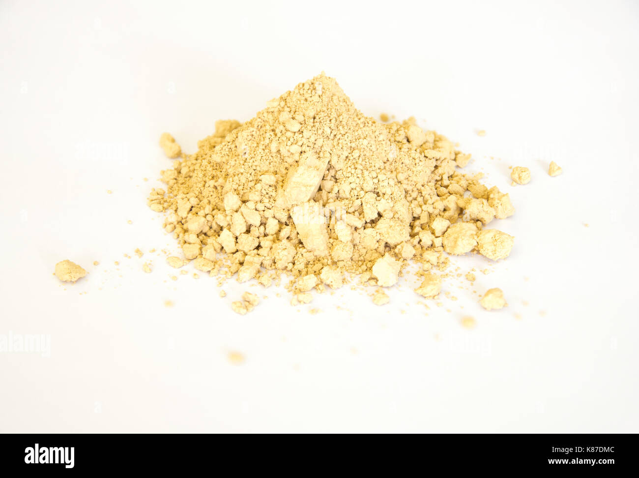 extreme close up of french ochre pigment isolated over white background ...