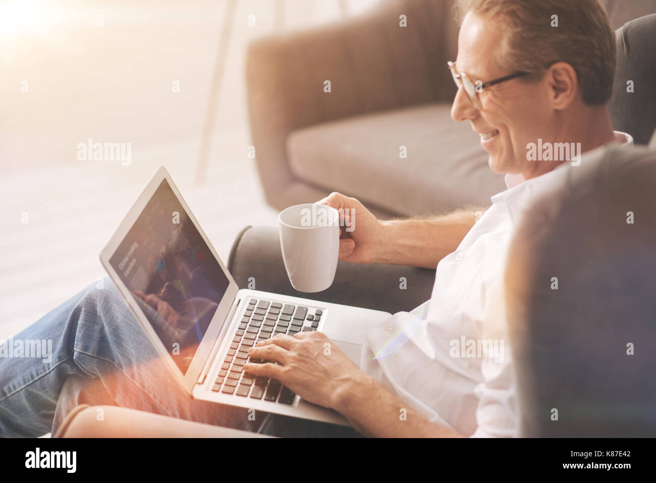 Positive nice man looking at the laptop screen Stock Photo - Alamy
