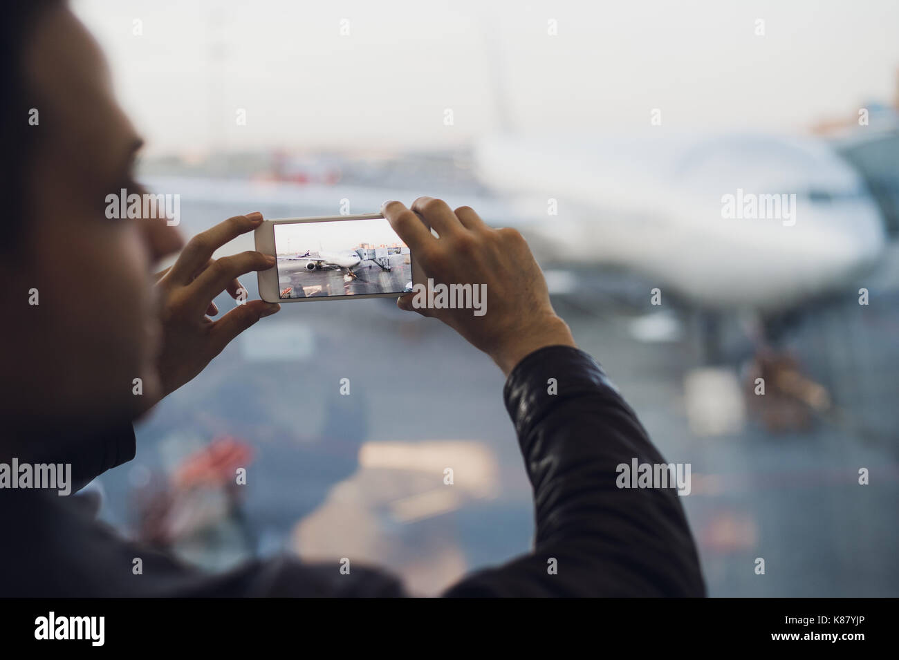traveler with mobile phone at the airport taking picture of his ...
