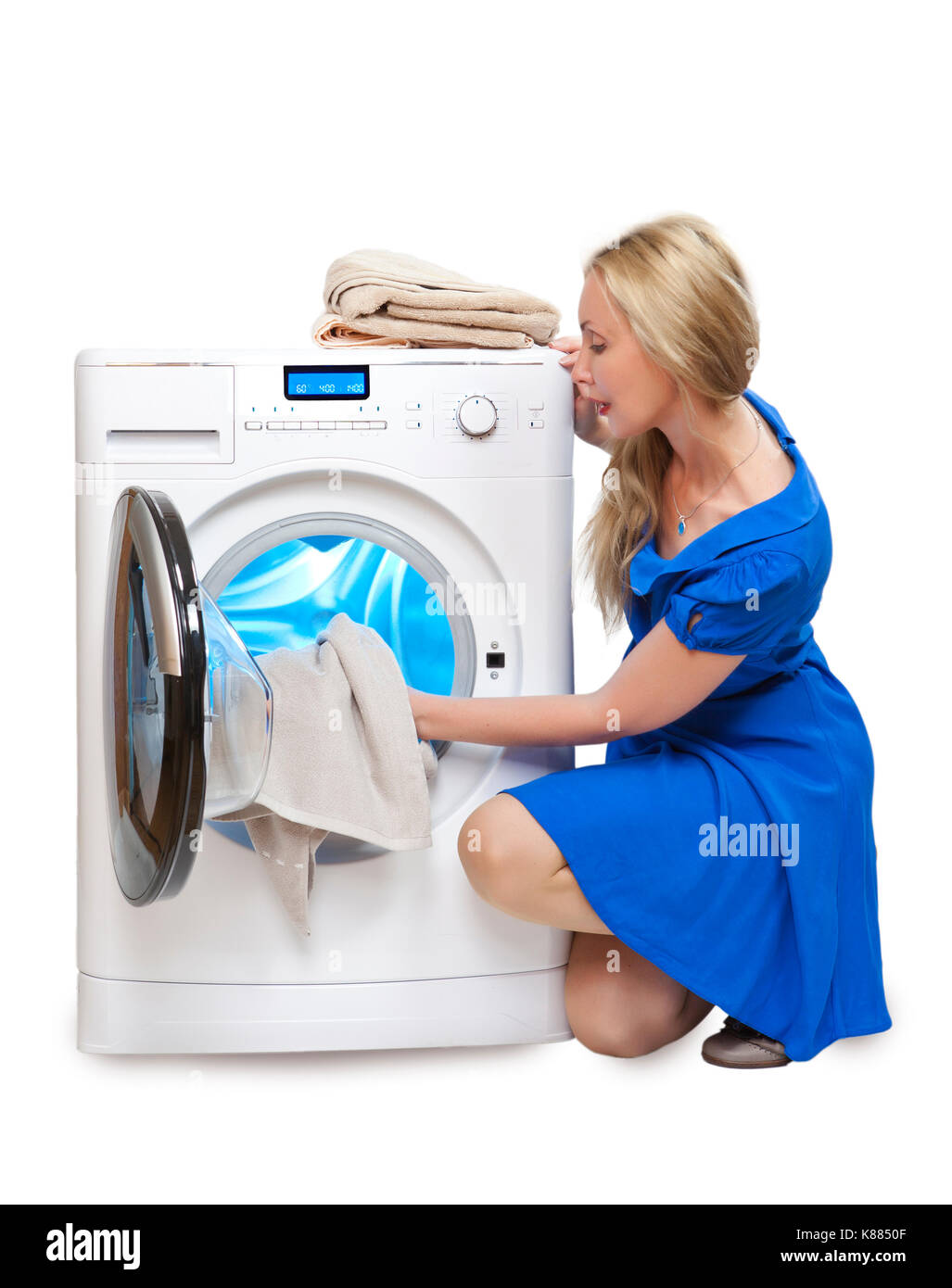 The young woman, the housewife, in a blue dress puts linen in the ...