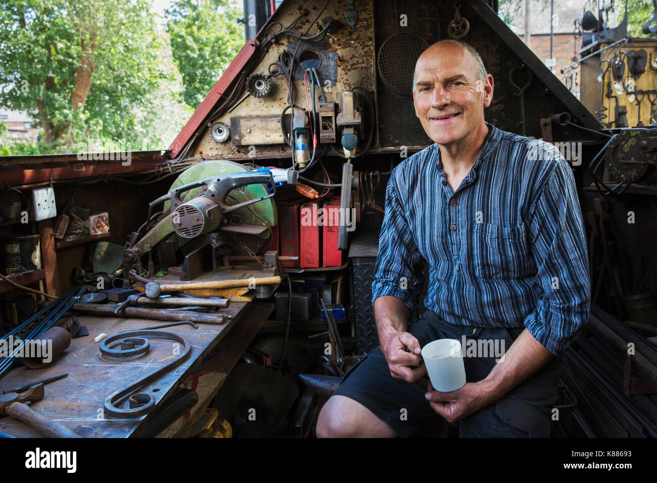 Blacksmith sitting on a working boat, a narrowboat on a waterway ...