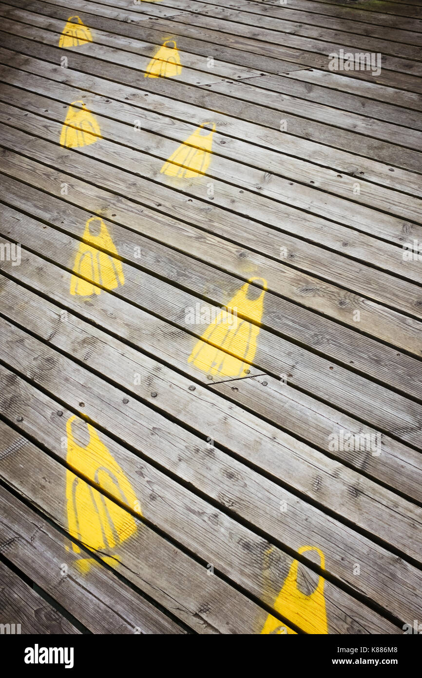 Yellow footprints on a traditional wooden pier in a coastal town Stock ...