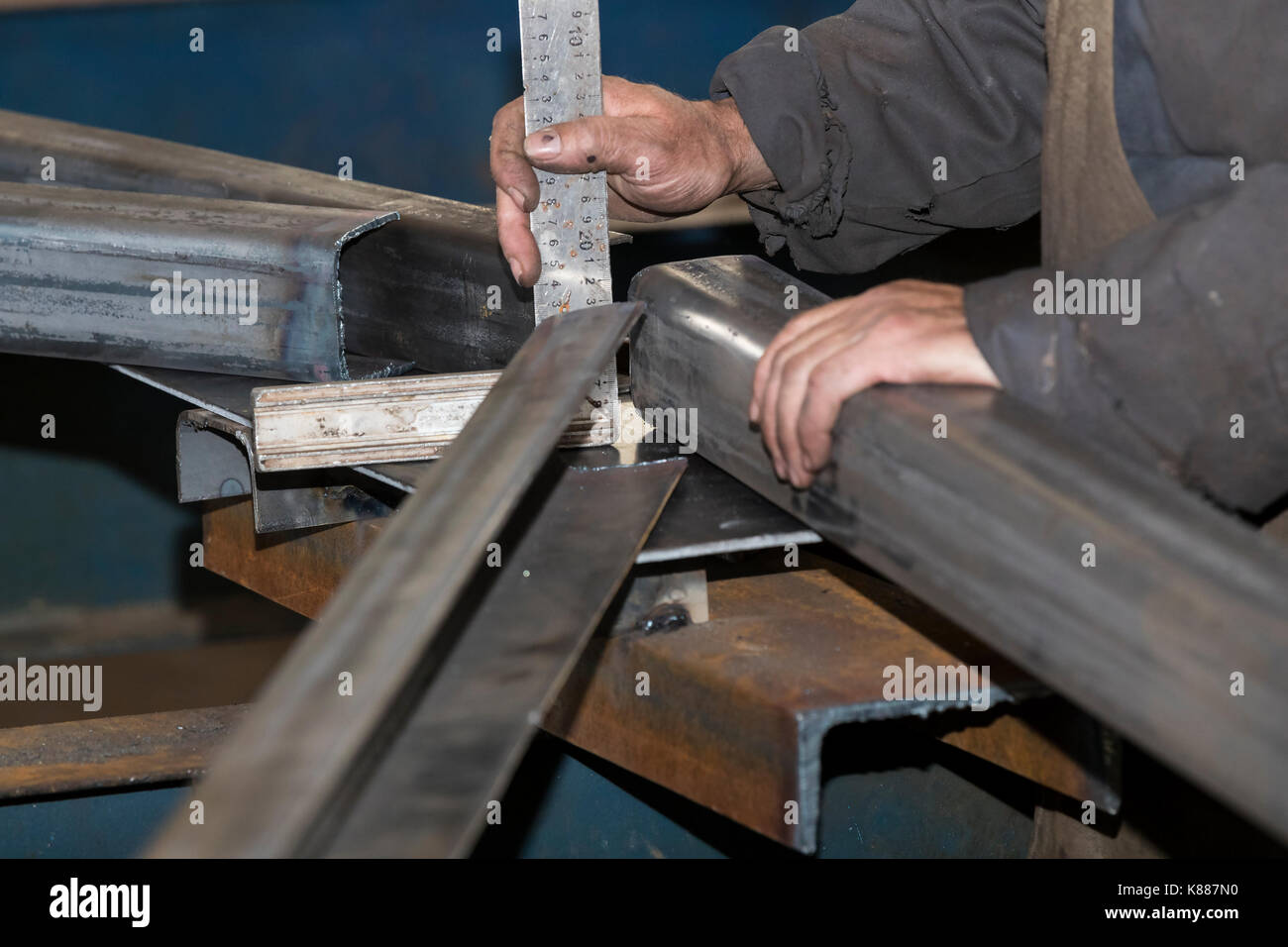 Metalworking shop workers work behind machines and apparatuses to ...