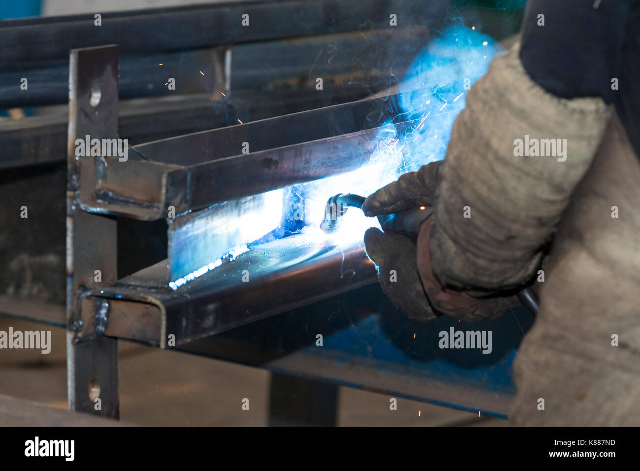 Metalworking shop workers work behind machines and apparatuses to ...