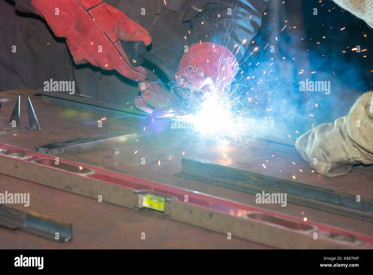 Metalworking shop workers work behind machines and apparatuses to ...