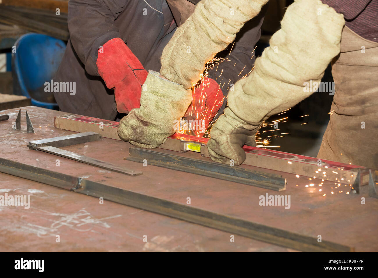 Metalworking shop workers work behind machines and apparatuses to ...