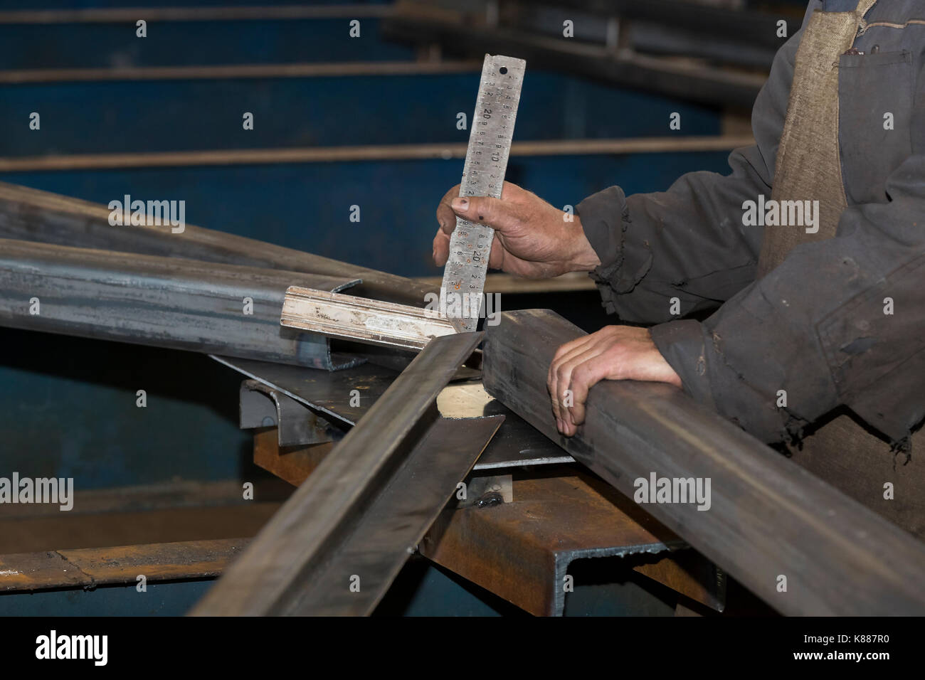 Metalworking shop workers work behind machines and apparatuses to ...