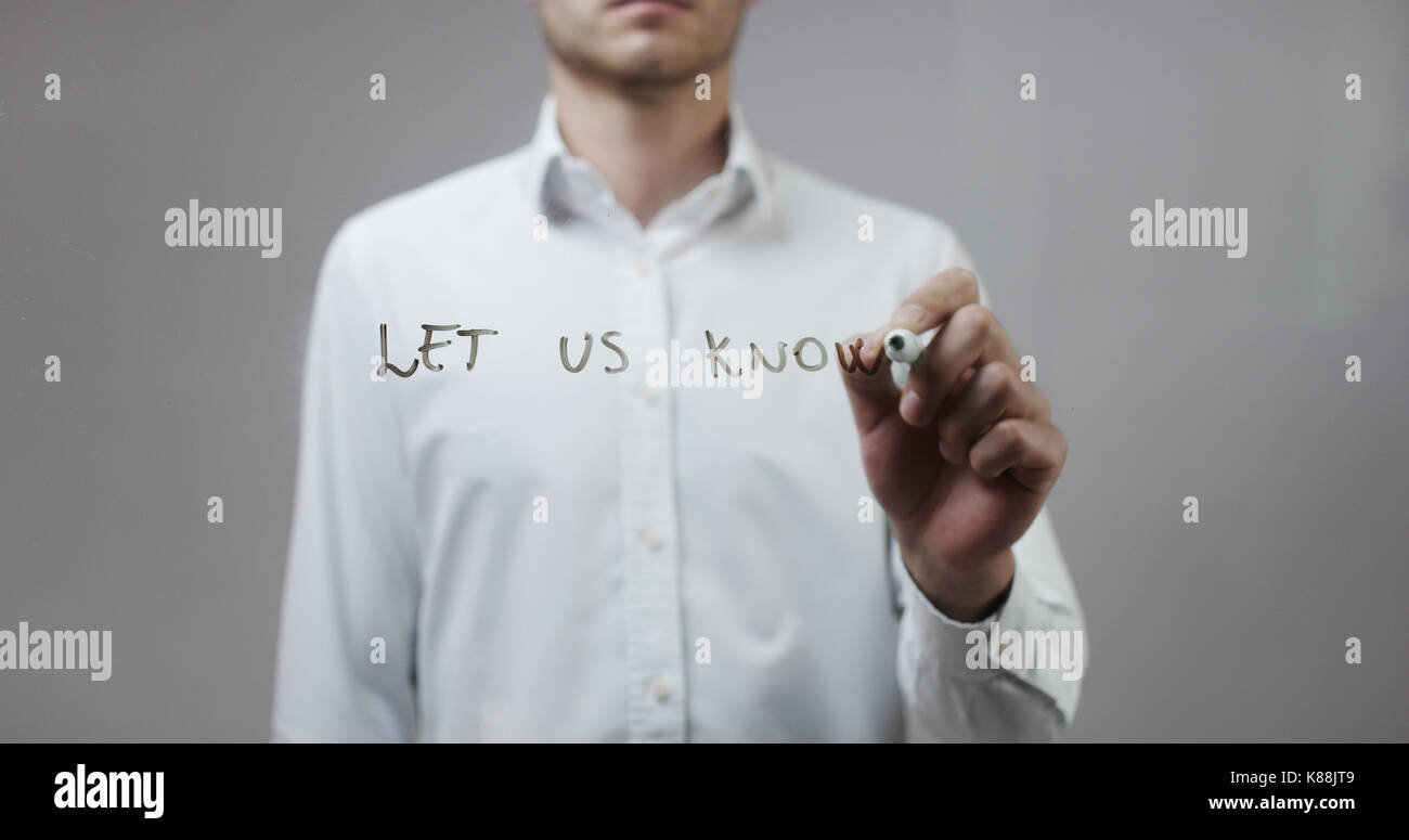 Let us know, Man Writing on Glass Stock Photo - Alamy