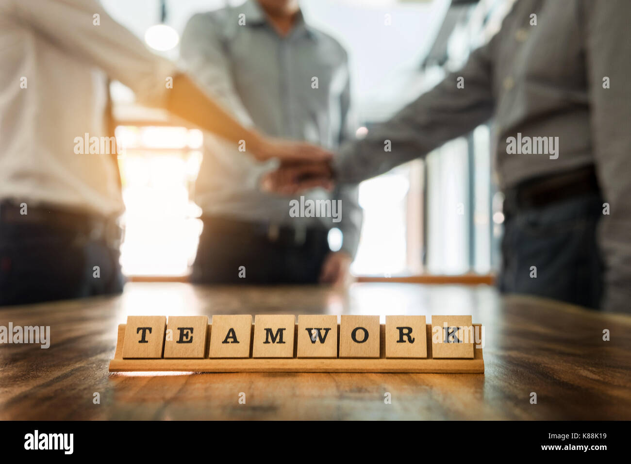 Teamwork word on wood table with Business team work join hands together ...
