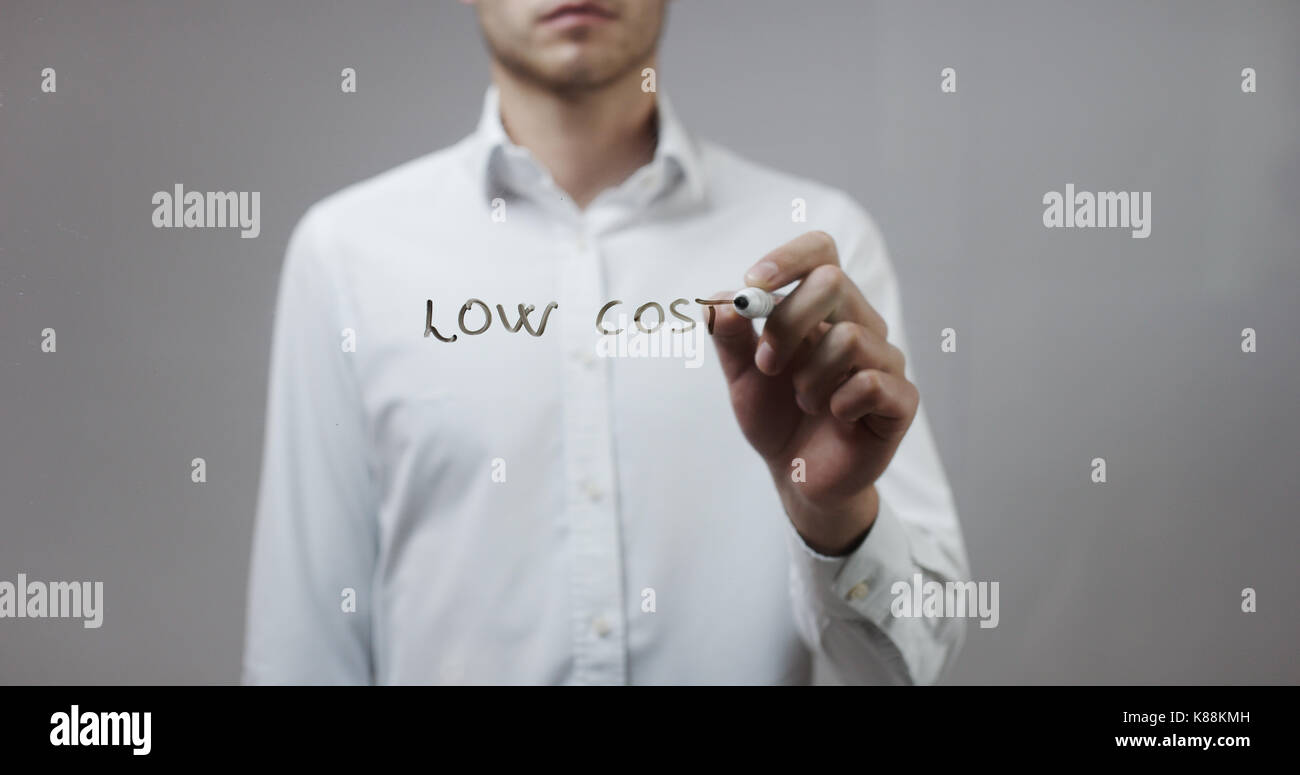 Low cost , Man Writing on Glass Stock Photo - Alamy