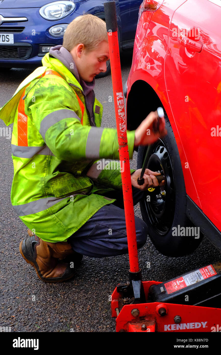 Mechanic changing a flat tyre Stock Photo - Alamy