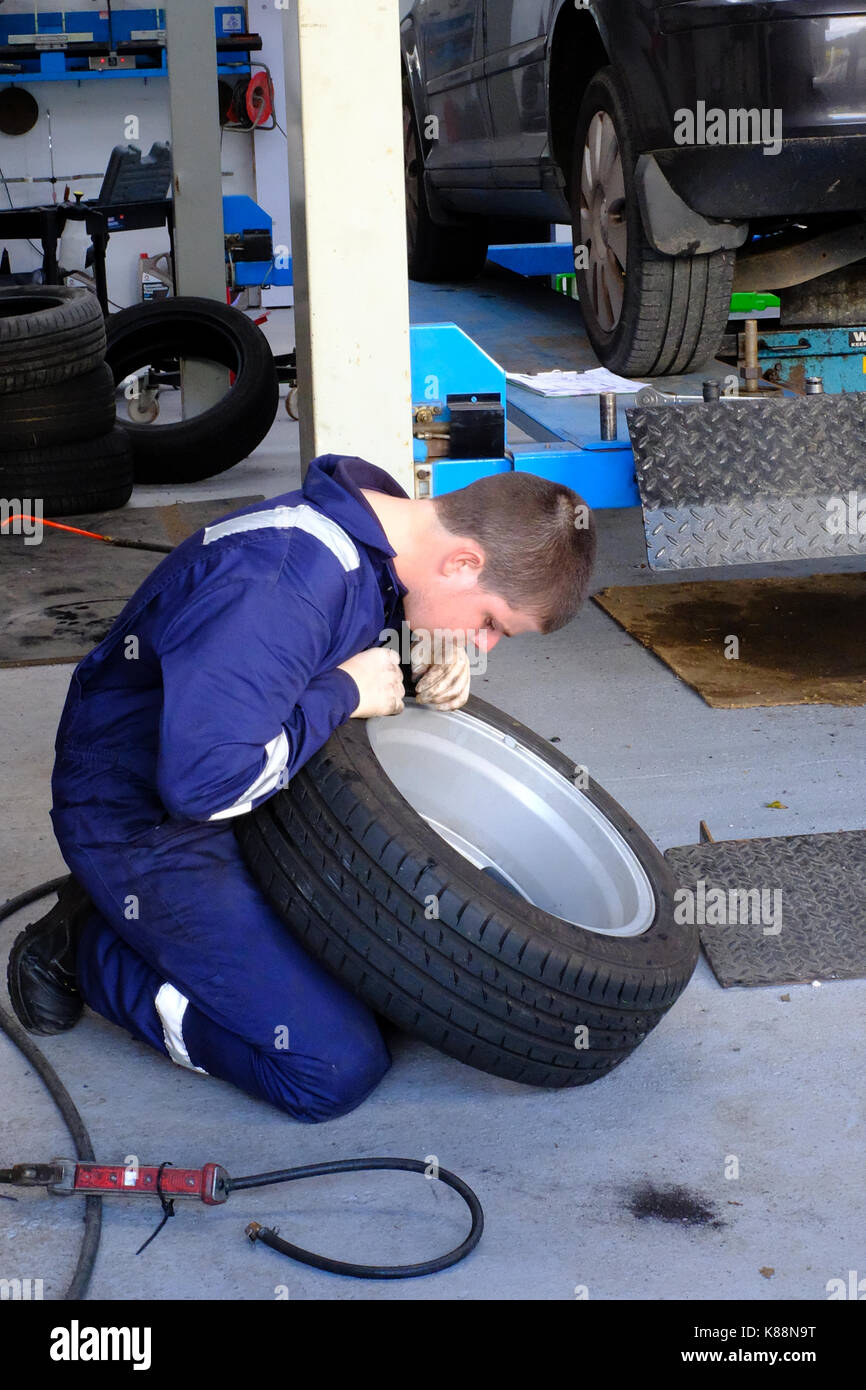 Mechanic changing a flat tyre Stock Photo - Alamy