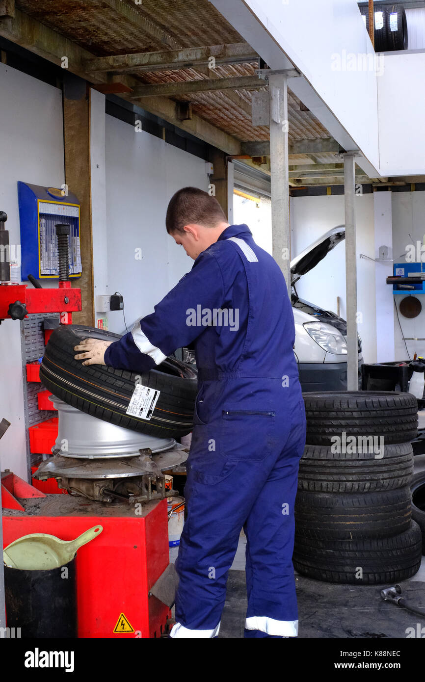 Mechanic changing a flat tyre Stock Photo - Alamy