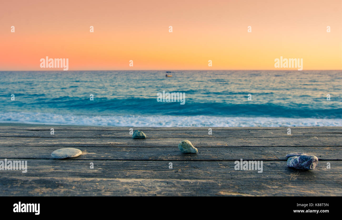 Summer view of a beach at sunset with stones on a table, Tertsa, Crete ...
