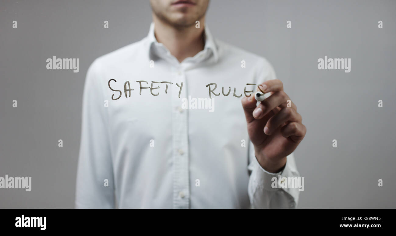 Safety rules , Man Writing on Glass Stock Photo - Alamy