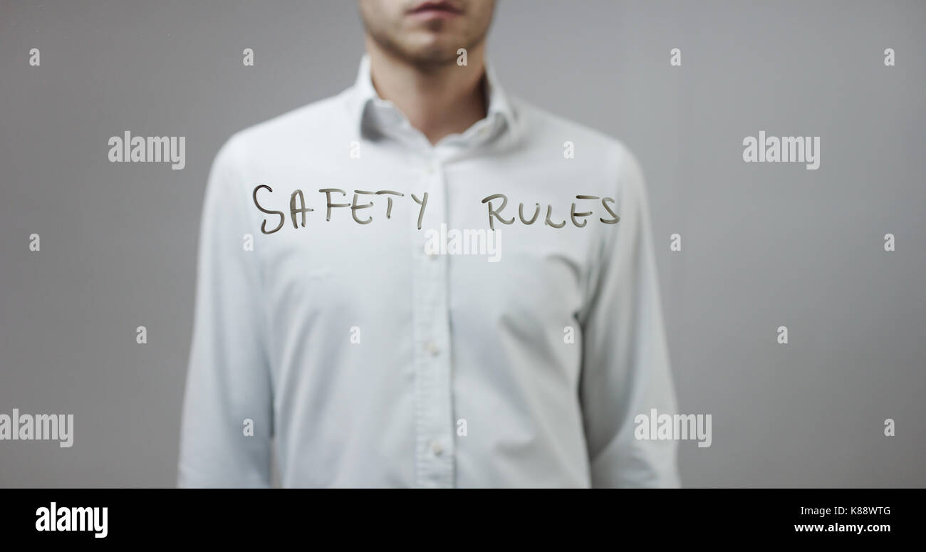 Safety rules , Man Writing on Glass Stock Photo - Alamy