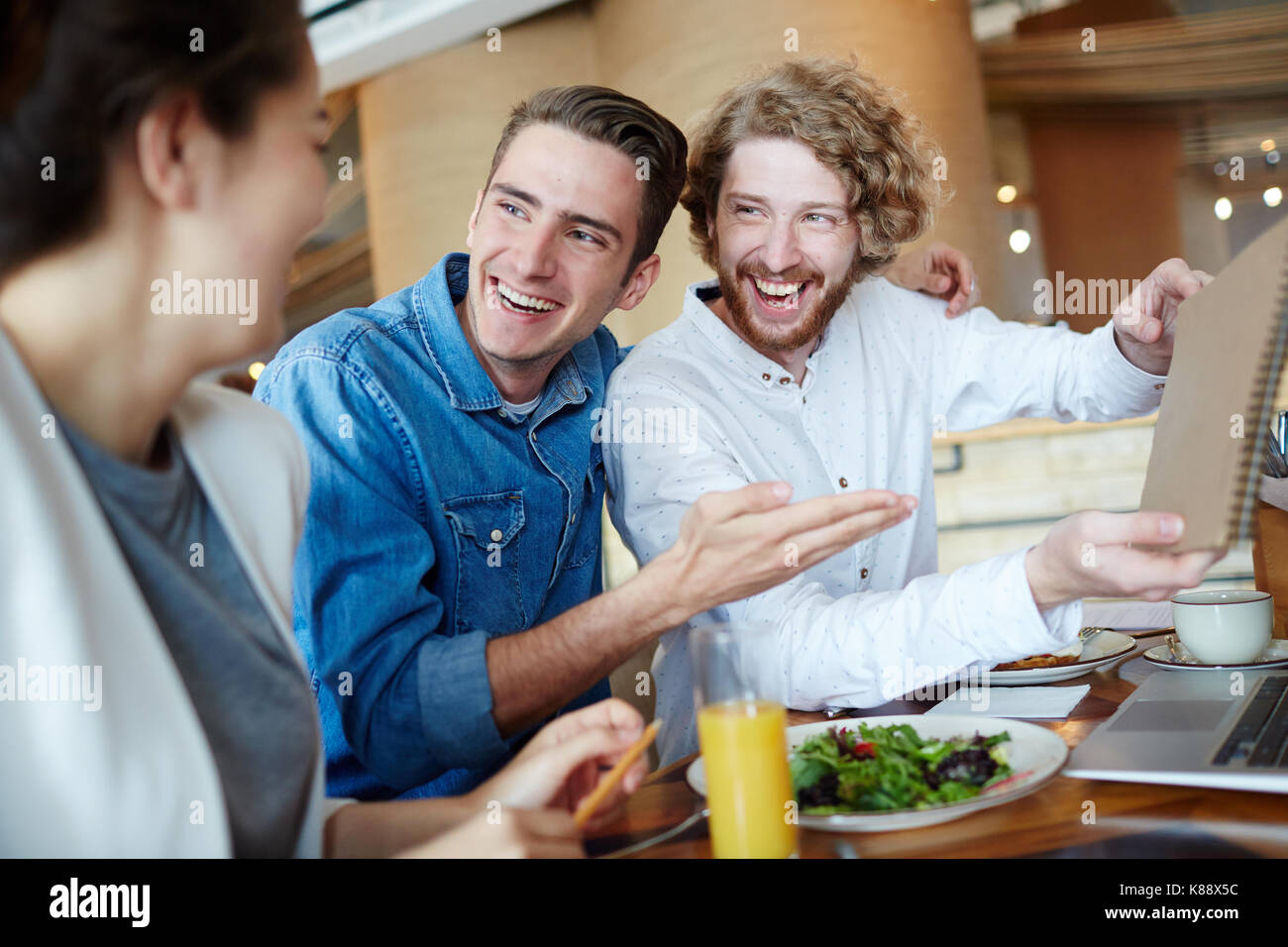 Joyful group of managers having fun while working together on joint ...