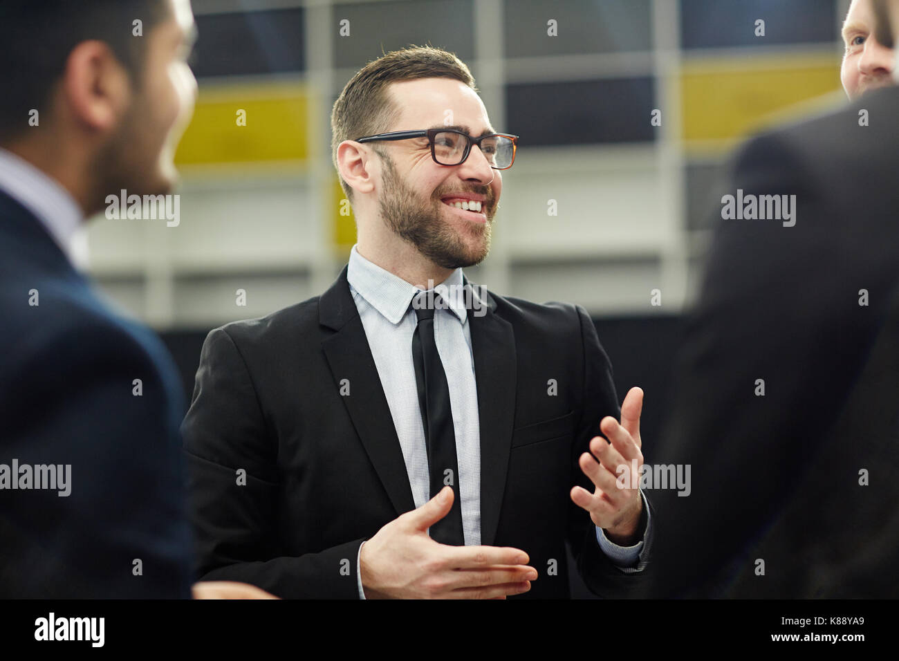Happy professional talking to his colleagues about new business ...