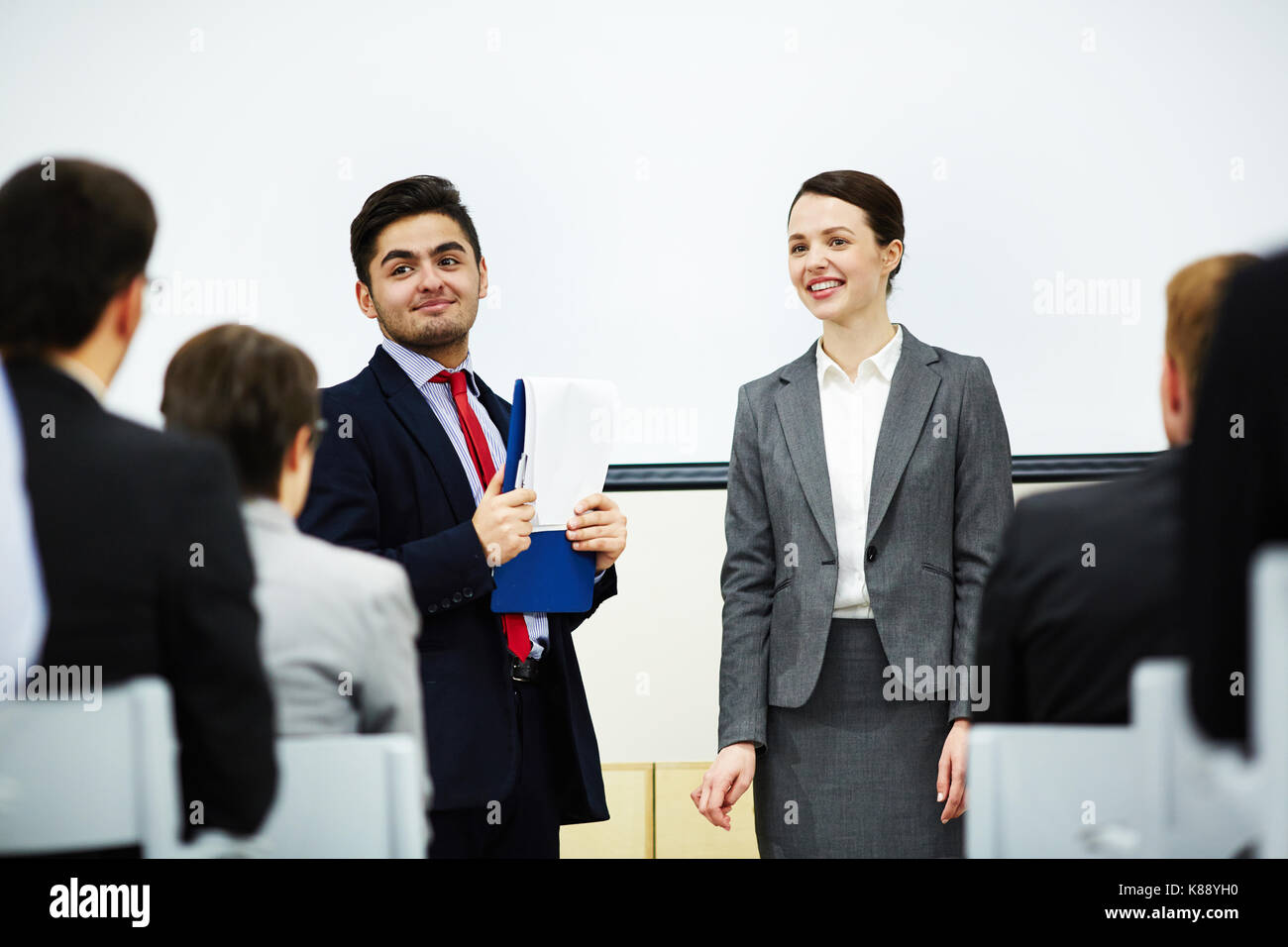 Successful businessman introducing his co-worker to audience who is ...
