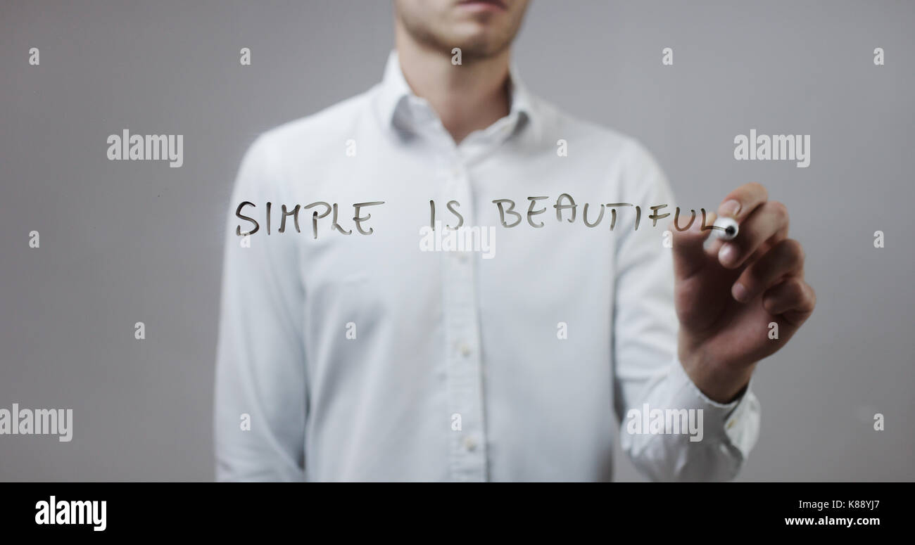 Simple is beautiful , Man Writing on Glass Stock Photo - Alamy