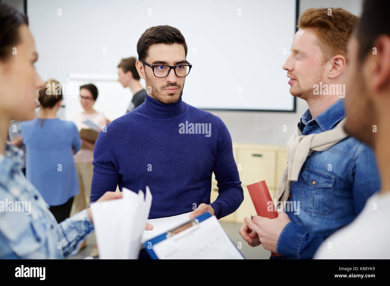 Confident student listening to ideas of his groupmates during ...