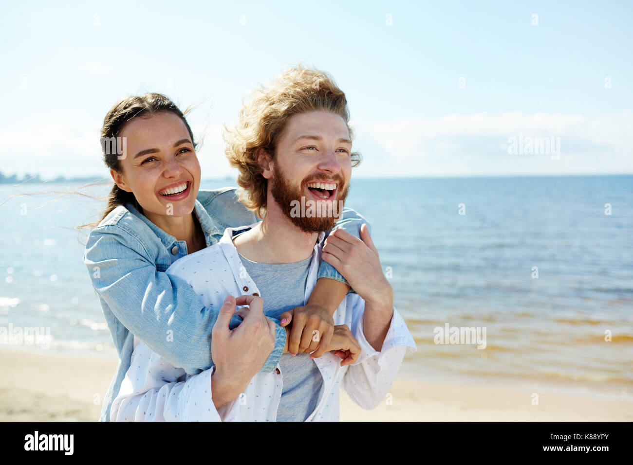 Ecstatic female embracing her happy husband while both enjoying summer ...