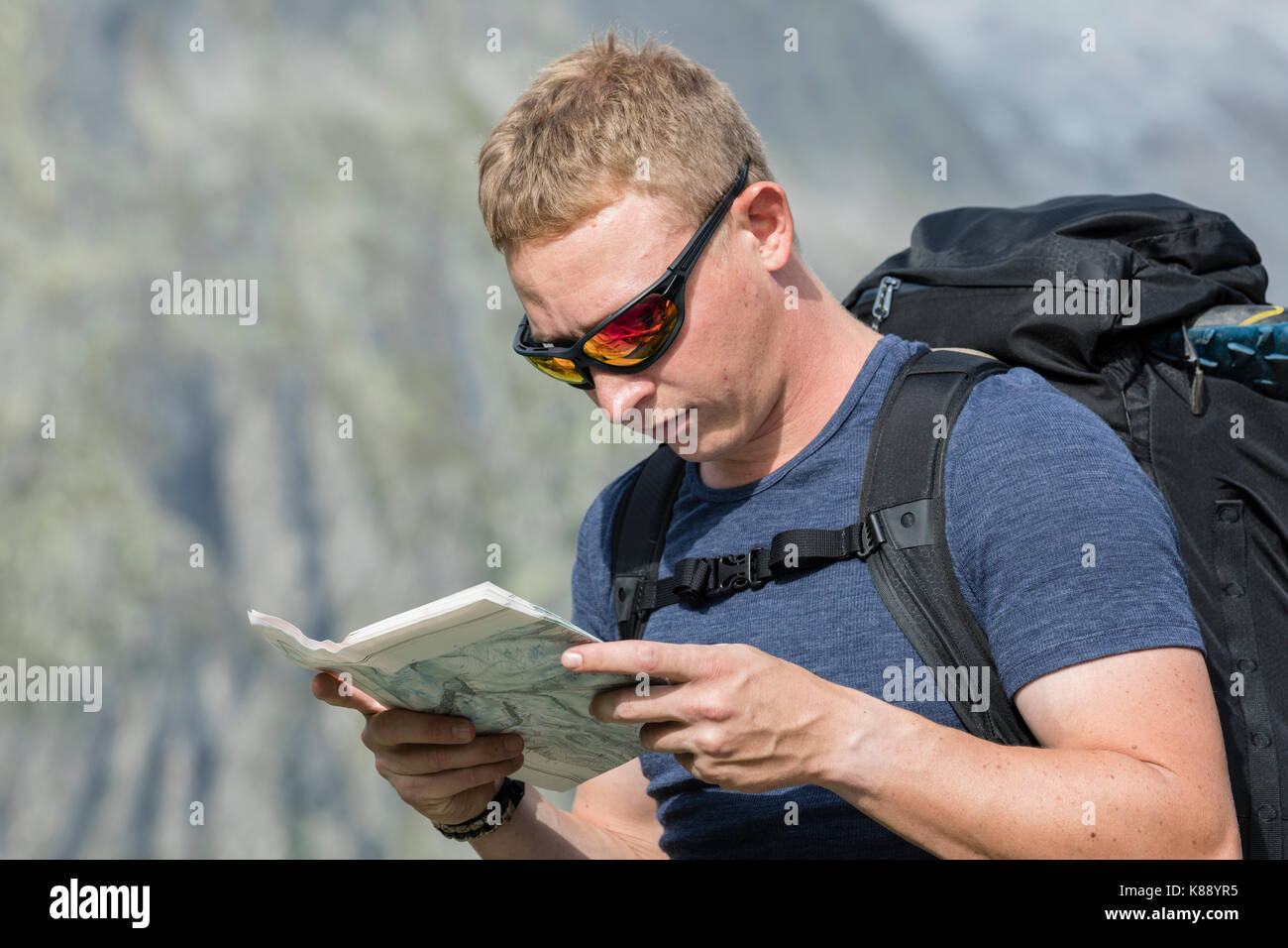 Hiker oriented with a map in the terrain Stock Photo - Alamy