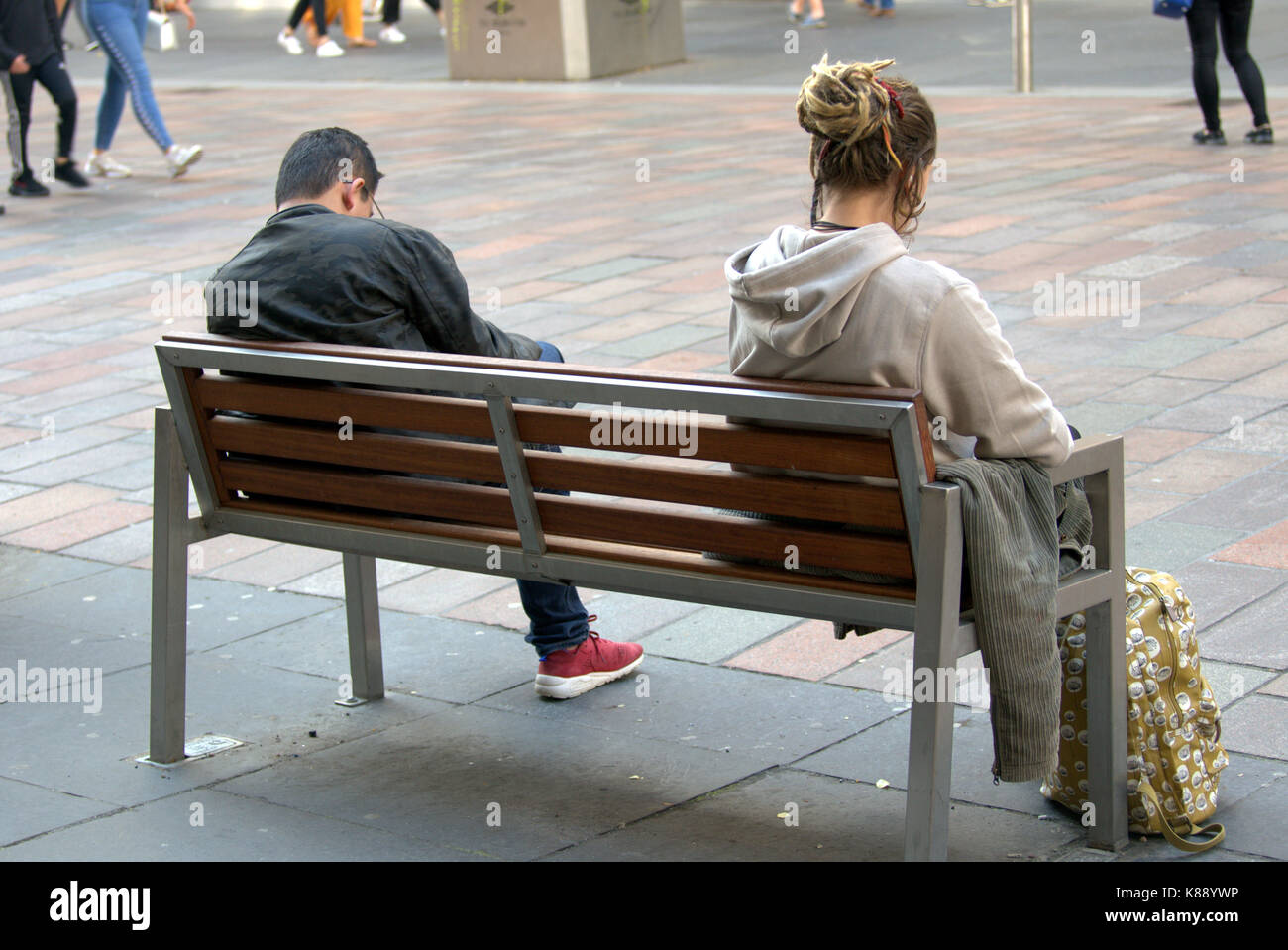 Chinese boy trendy white girl strangers sitting on a bench on Buchanan ...
