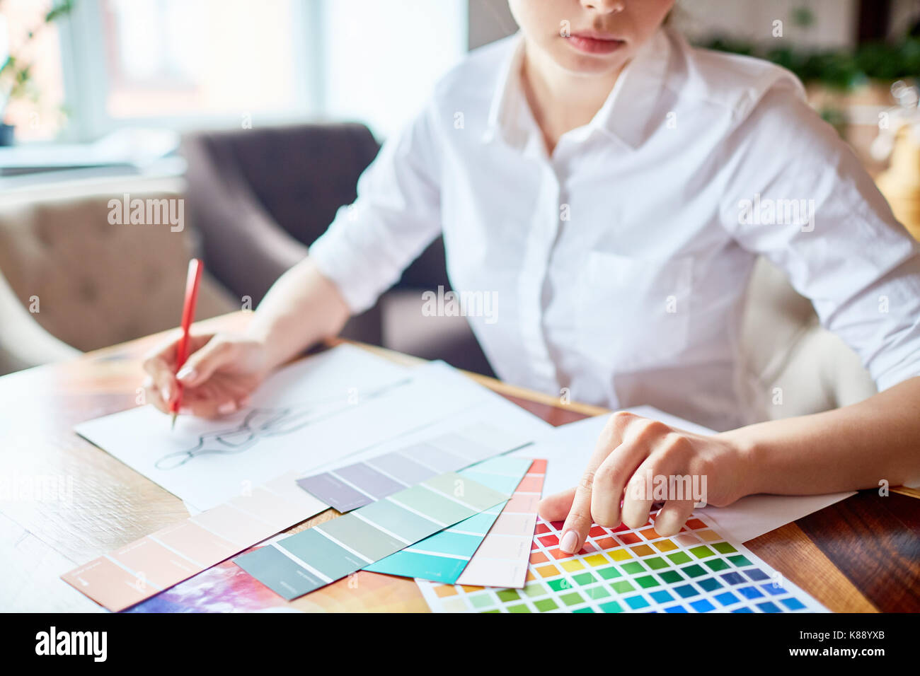 Young fashion designer choosing suitable colors for seasonal collection ...