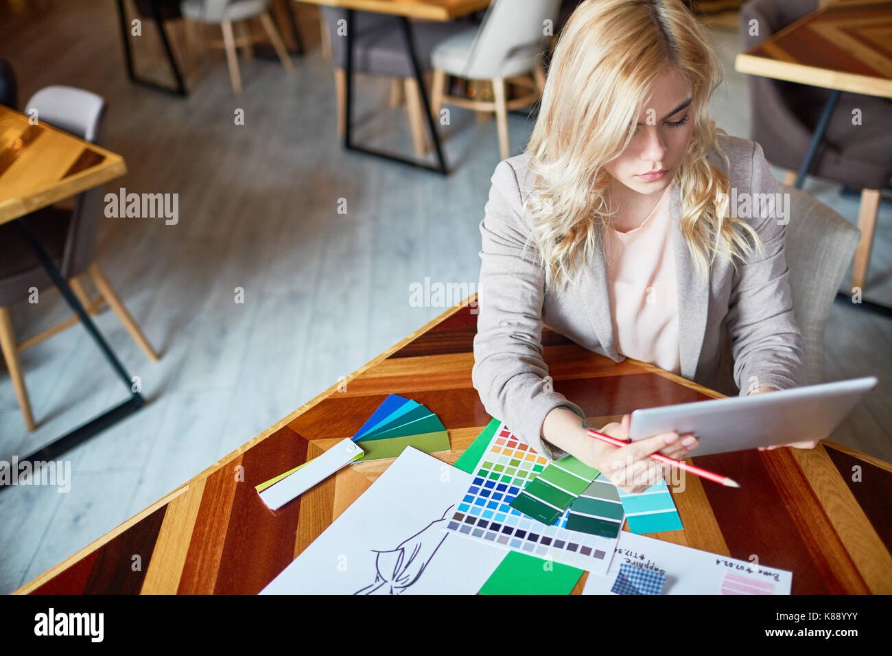 Creative fashion designer with touchpad looking for up-to-date trends ...