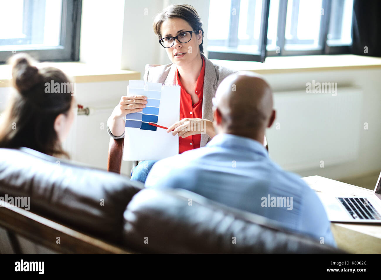 Creative designer of interior giving advice to her clients about choice ...