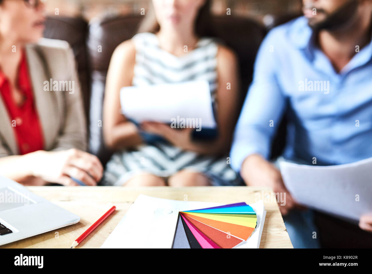 Pencil and color palette on workplace with three interior designers ...